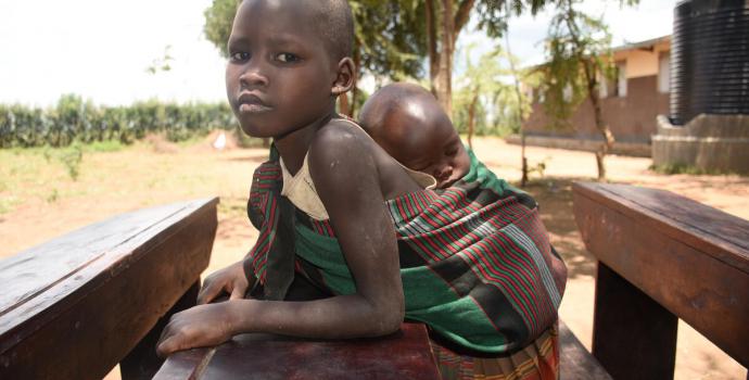 Children in North East Uganda take younger siblings to school for food ...